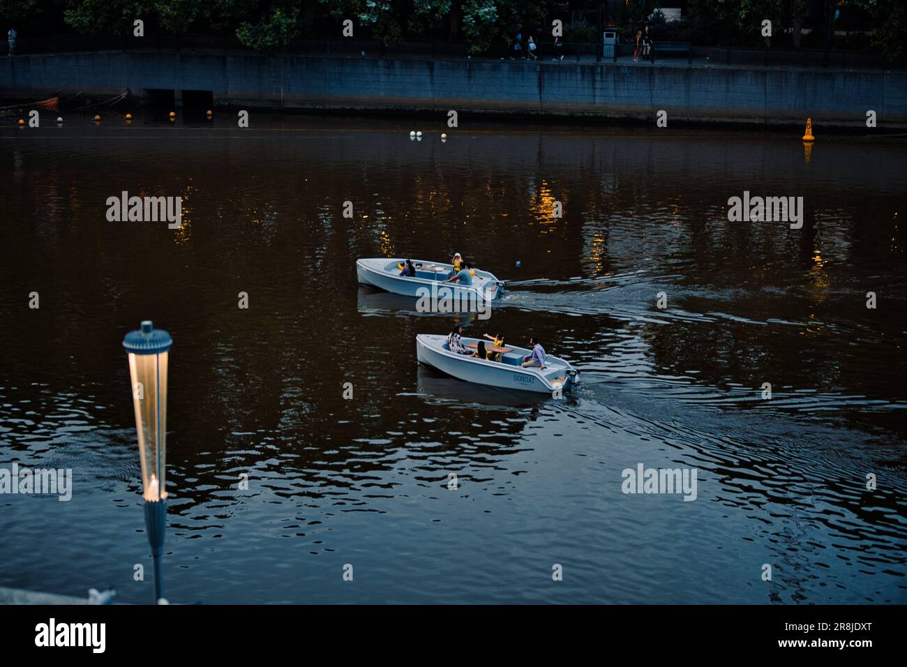 Two sleek vessels are sailing in a large body of water near a beautiful ...