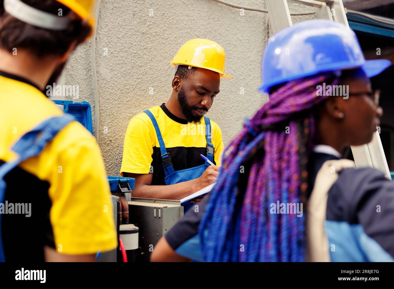 Diverse team of seasoned mechanics brainstorming possible ways to ...