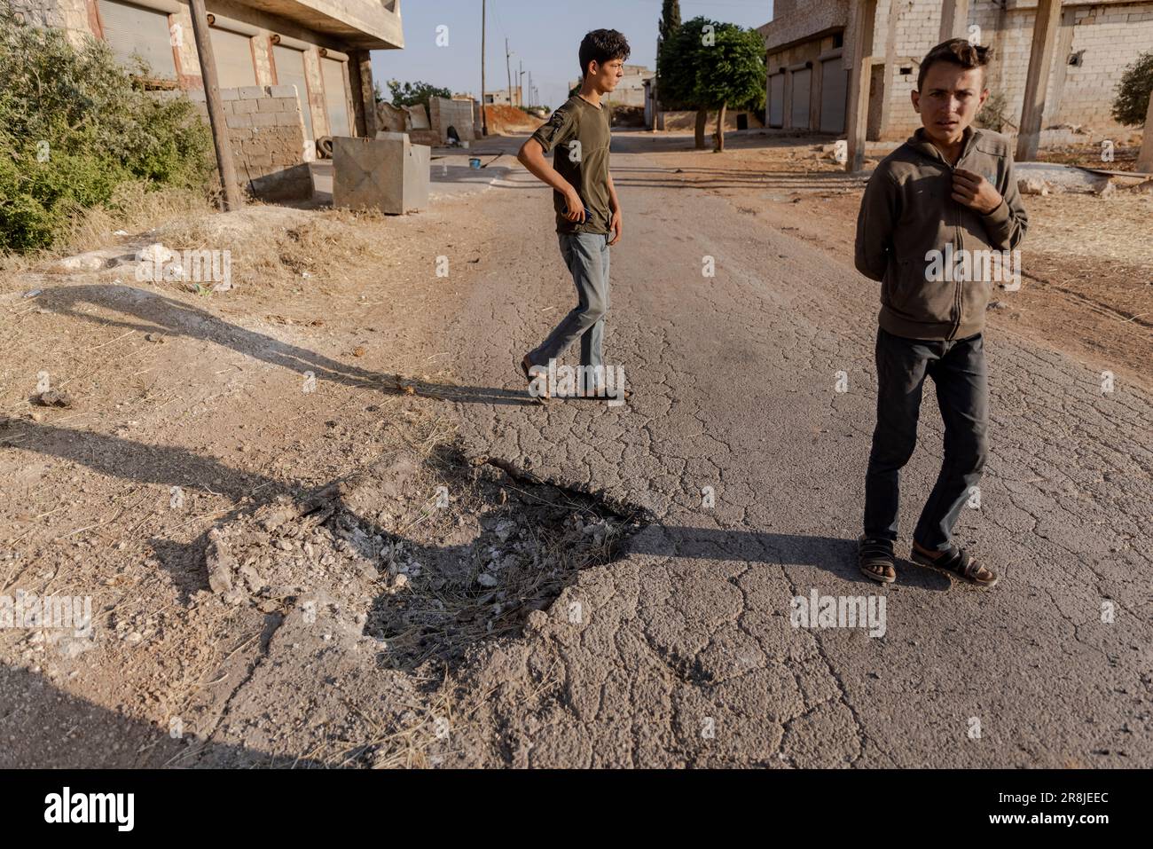 Kafr Nuran, Syria. 21st June, 2023. Children stand near a crater left ...