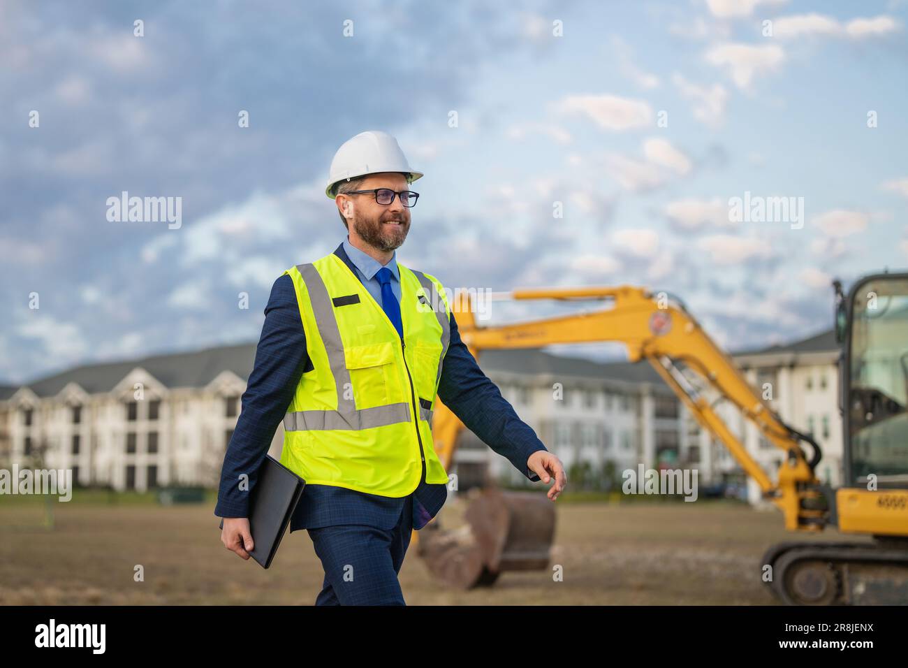 Architect at a construction site. Architect man in suit and helmet at ...