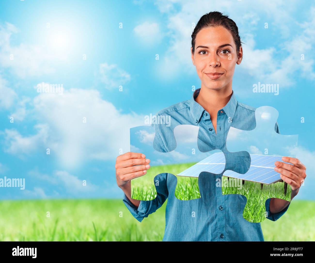 Woman holds two pieces of puzzle with solar panel on a green field ...