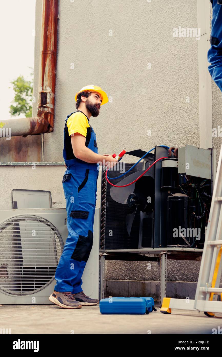 Meticulous workers diverse team doing routine air conditioner revision ...