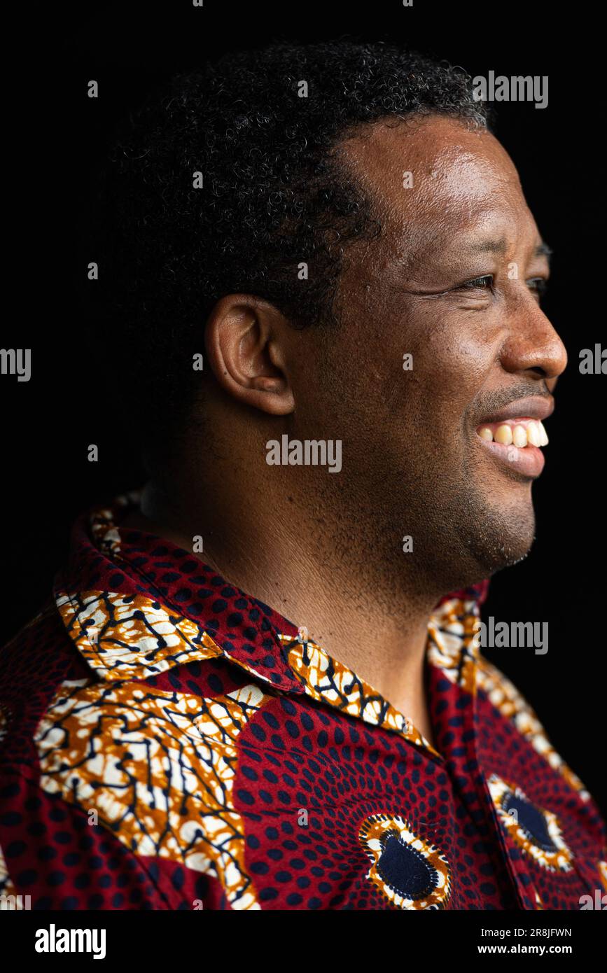 Portrait of handsome African man against black background smiling Stock ...