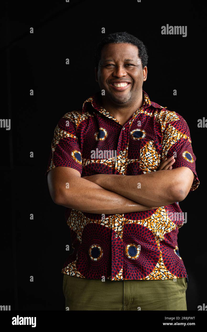 Portrait of handsome African man smiling with arms crossed against ...