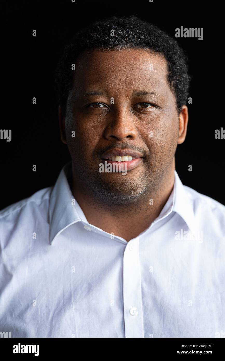 Portrait of handsome African man smiling against black background Stock ...