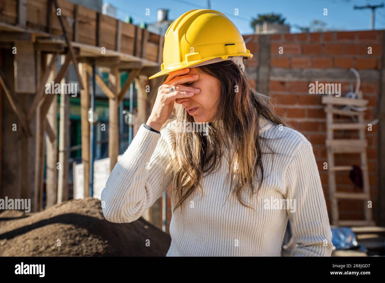 Portrait of worried or tired woman architect at a construction site ...