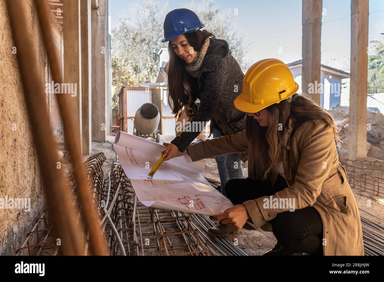 Women architects working in team, measuring in construction site with ...