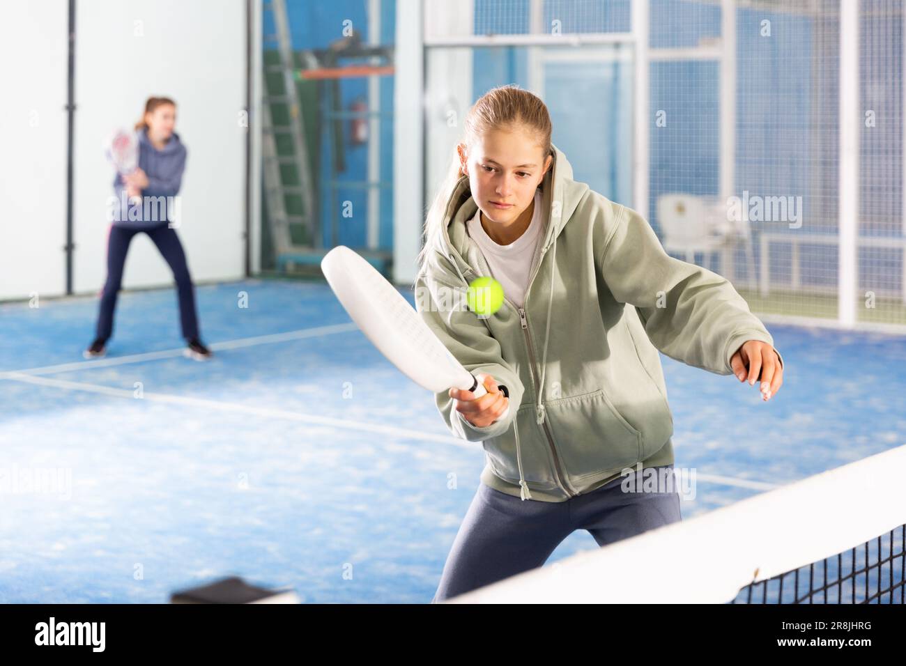 Teenage girl playing padel in court Stock Photo - Alamy