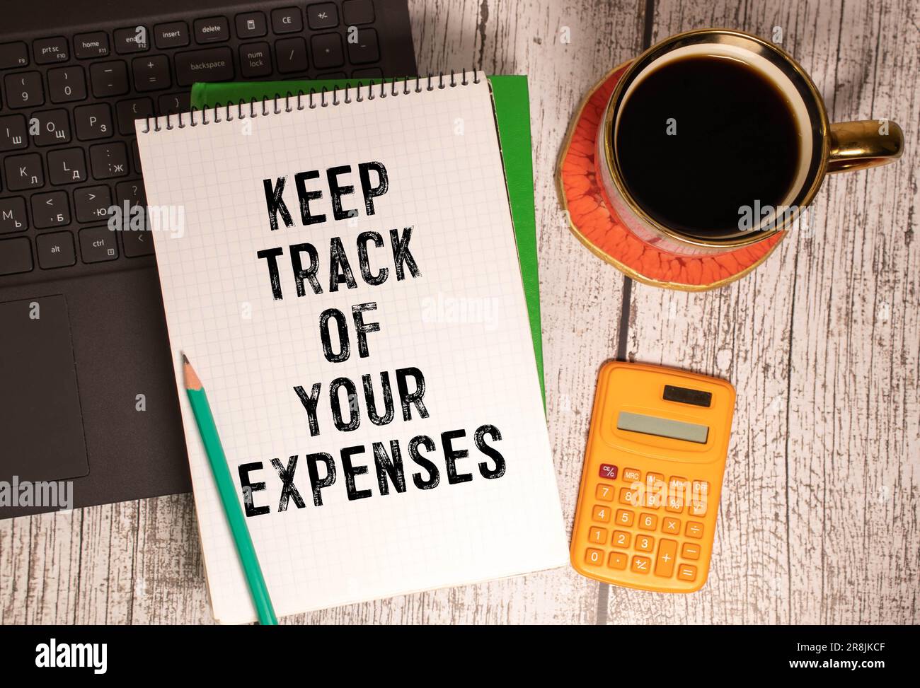 White card with the text Keep track of your expenses on wooden desk ...
