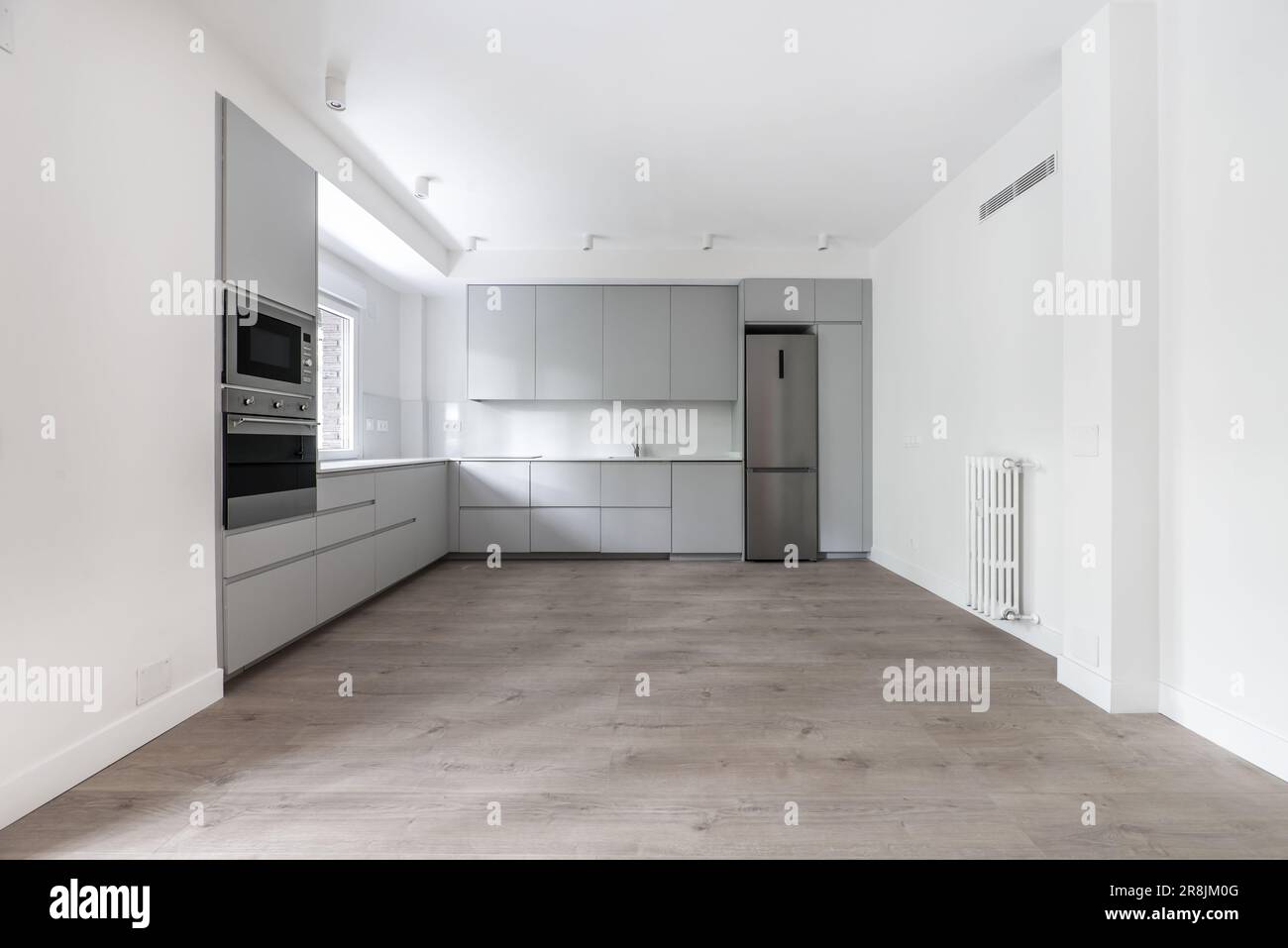 Newly installed modern kitchen covering two L-shaped walls with gray ...