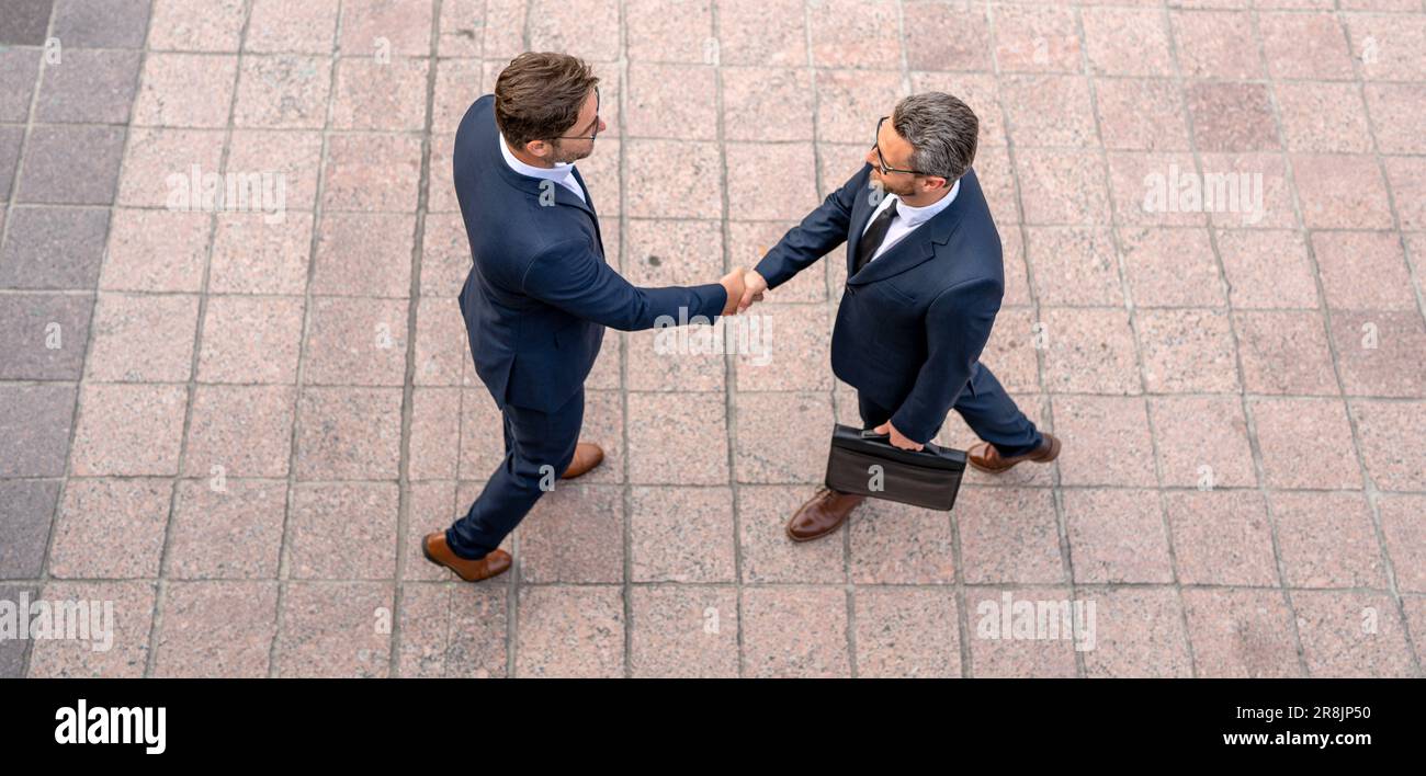 Handshake with partner in the city for greeting. Two businessmen ...