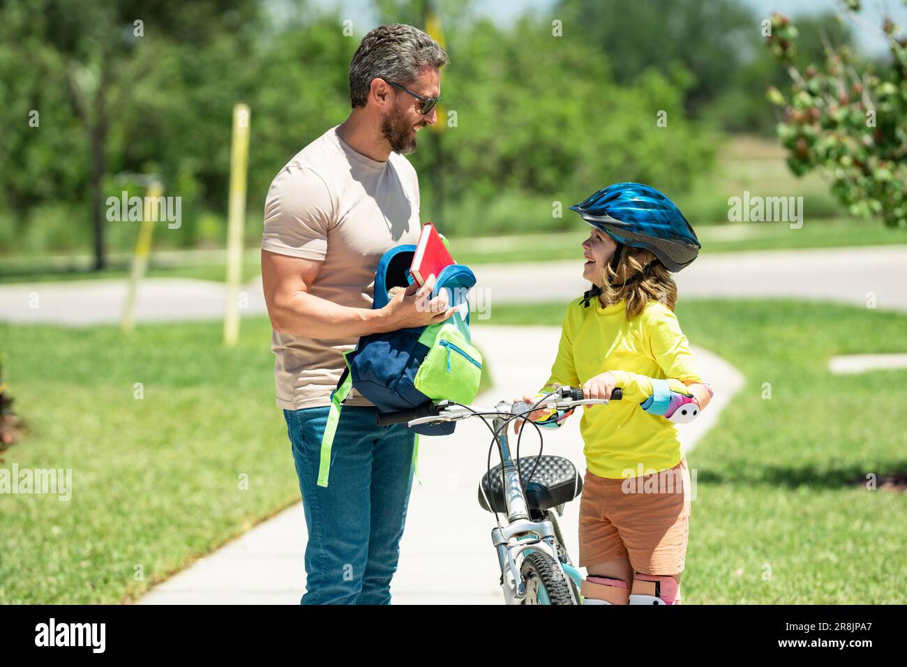Father and son on the bicycle. Father and son riding a bike in summer ...