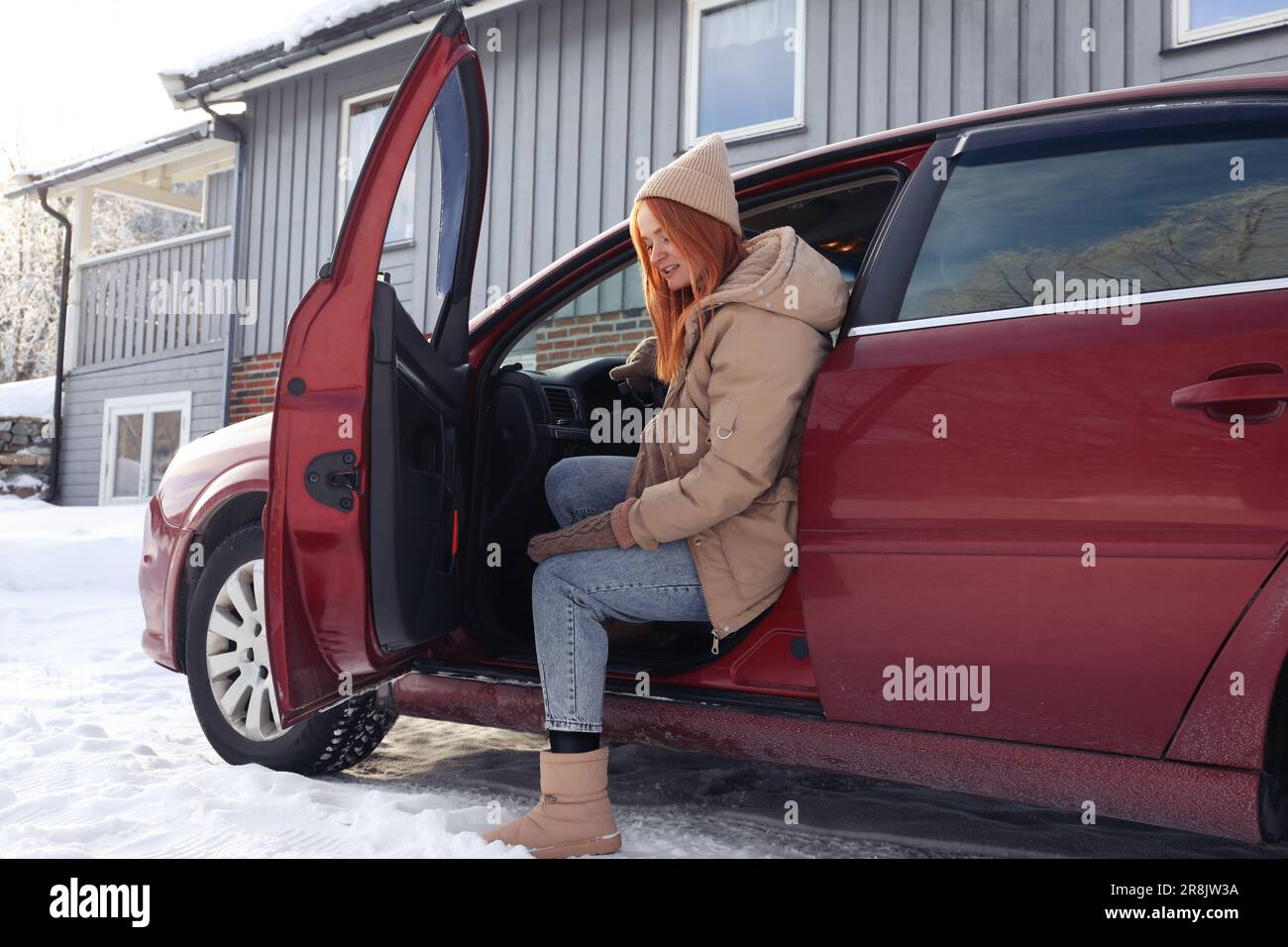 Beautiful young woman getting out of car. Winter vacation Stock Photo ...