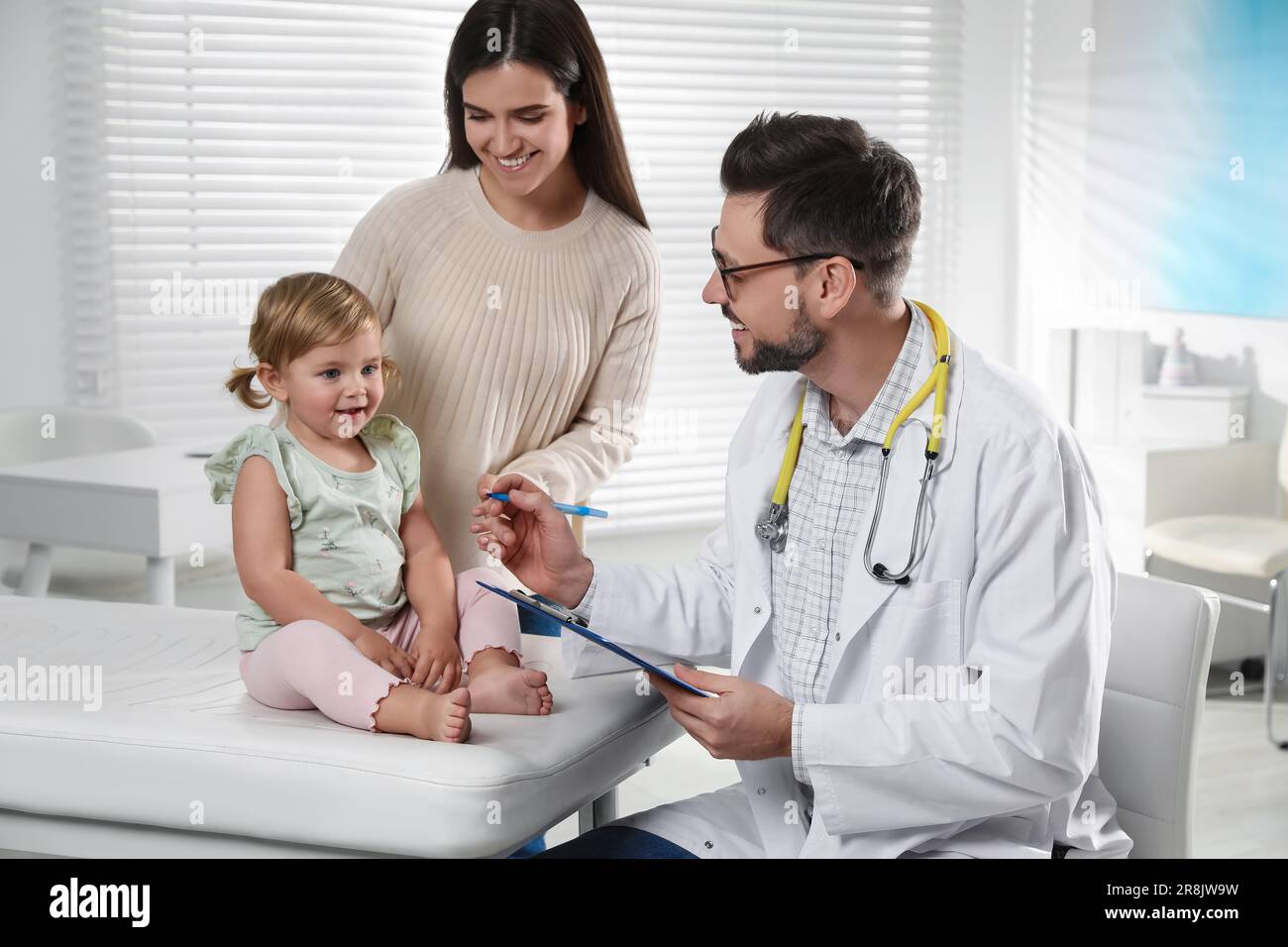 Mother and her cute baby having appointment with pediatrician in clinic ...
