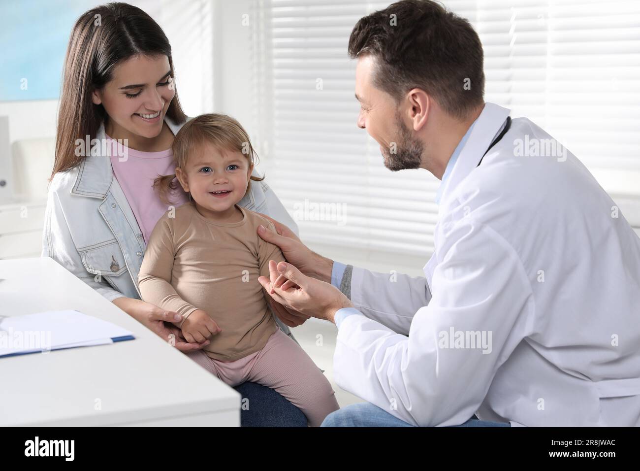 Mother and her cute baby having appointment with pediatrician in clinic ...