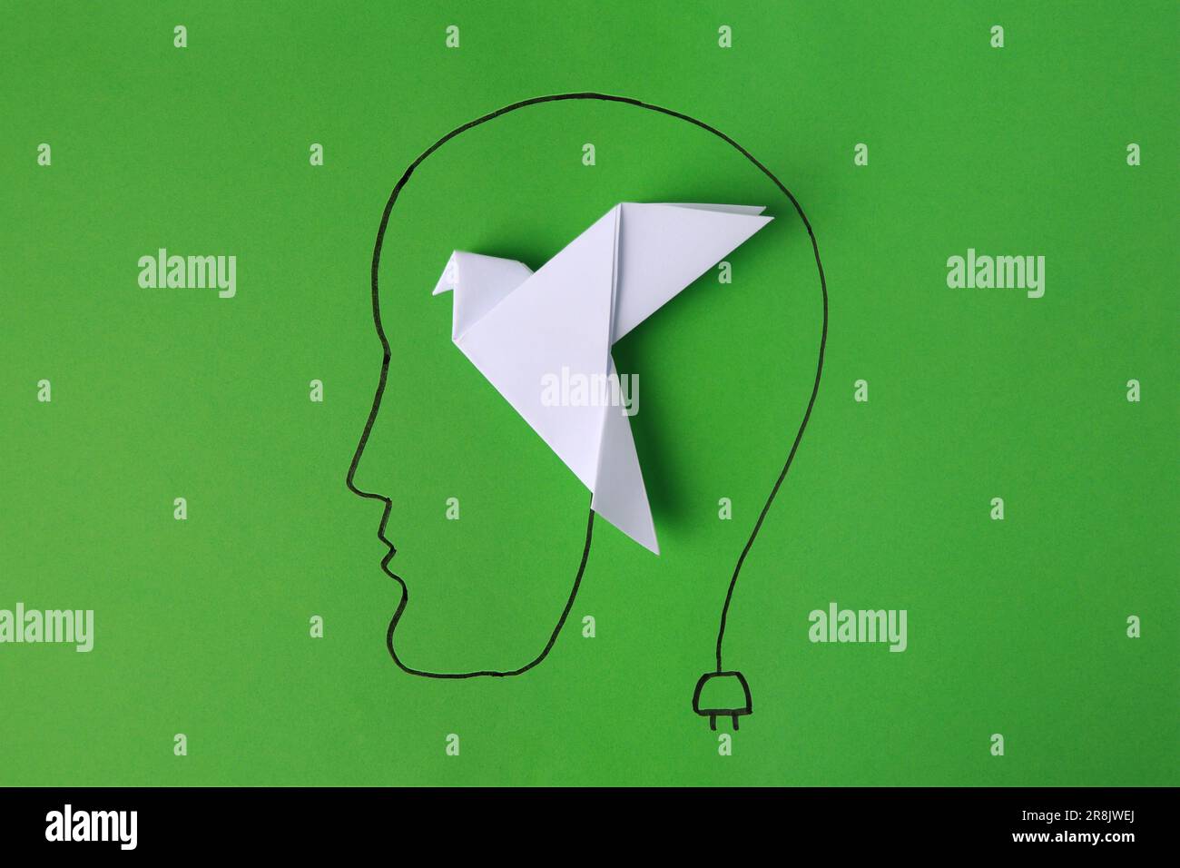 Drawn human head with white paper bird as solution idea on green ...