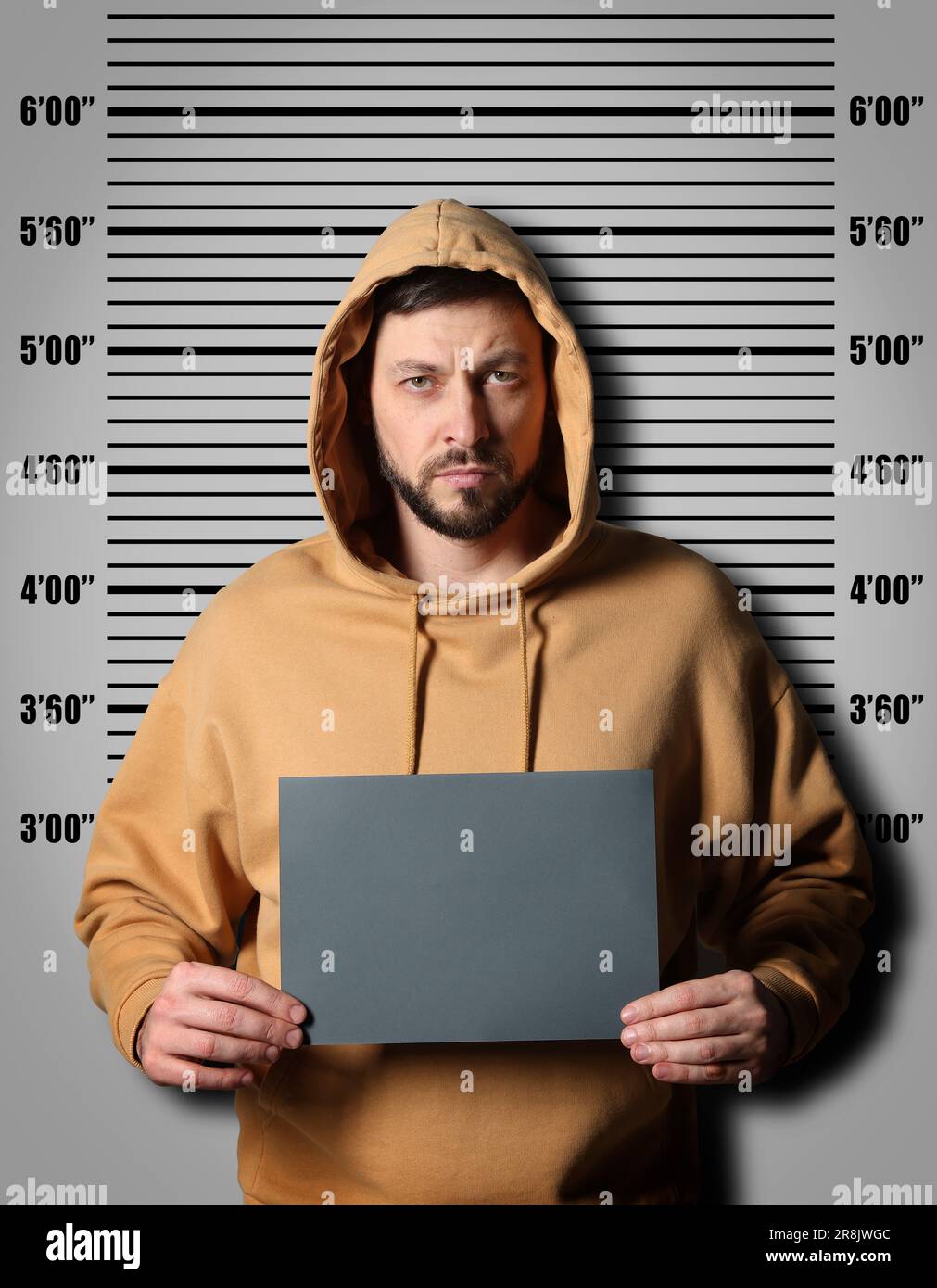 Criminal mugshot. Arrested man with blank card against height chart ...