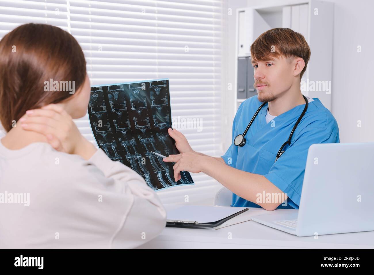 Doctor with neck MRI image consulting patient in clinic Stock Photo - Alamy