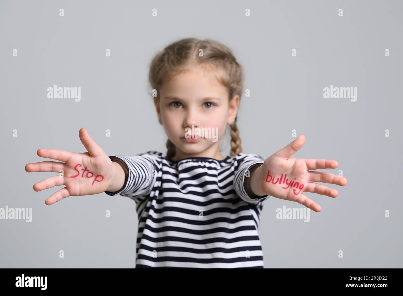 Girl showing hands with phrase Stop Bullying on light grey background ...