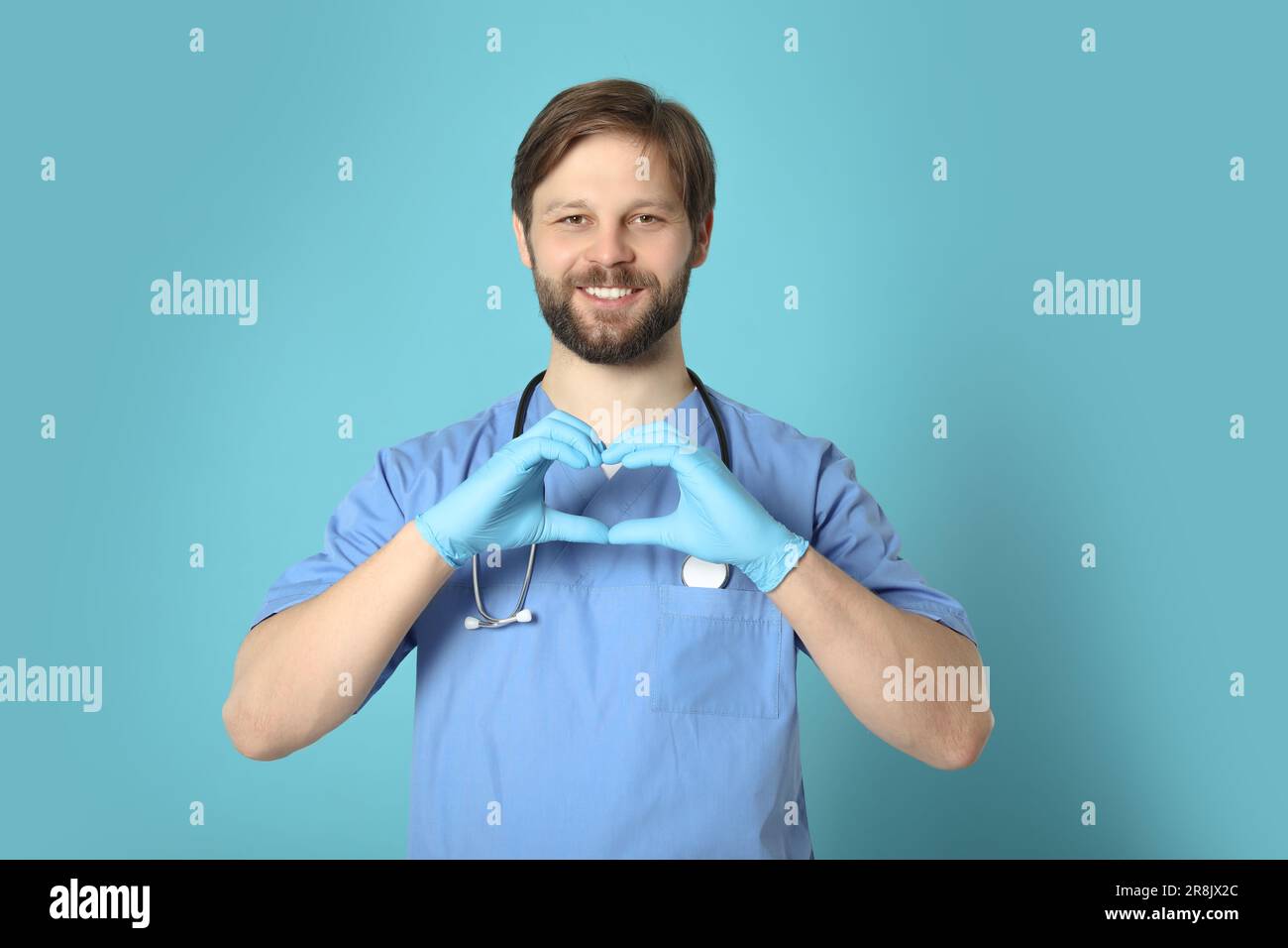 Doctor or medical assistant (male nurse) making heart with hands on ...