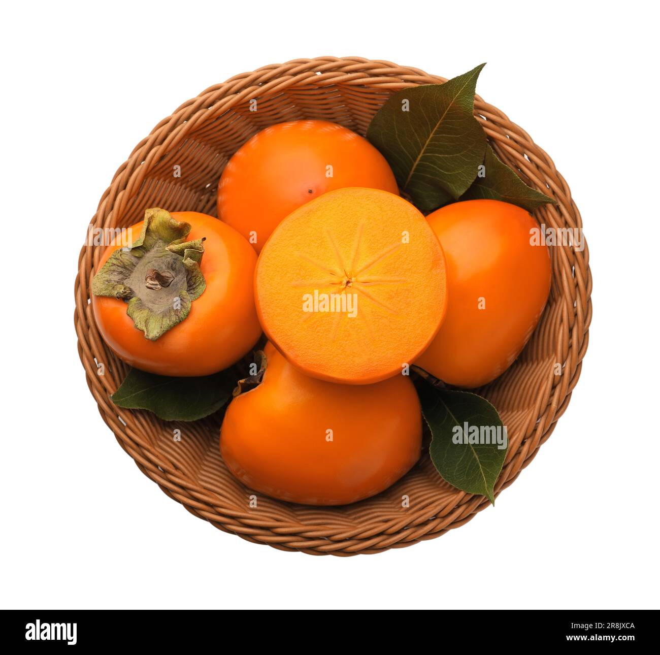 Delicious ripe persimmons in wicker basket on white background, top ...