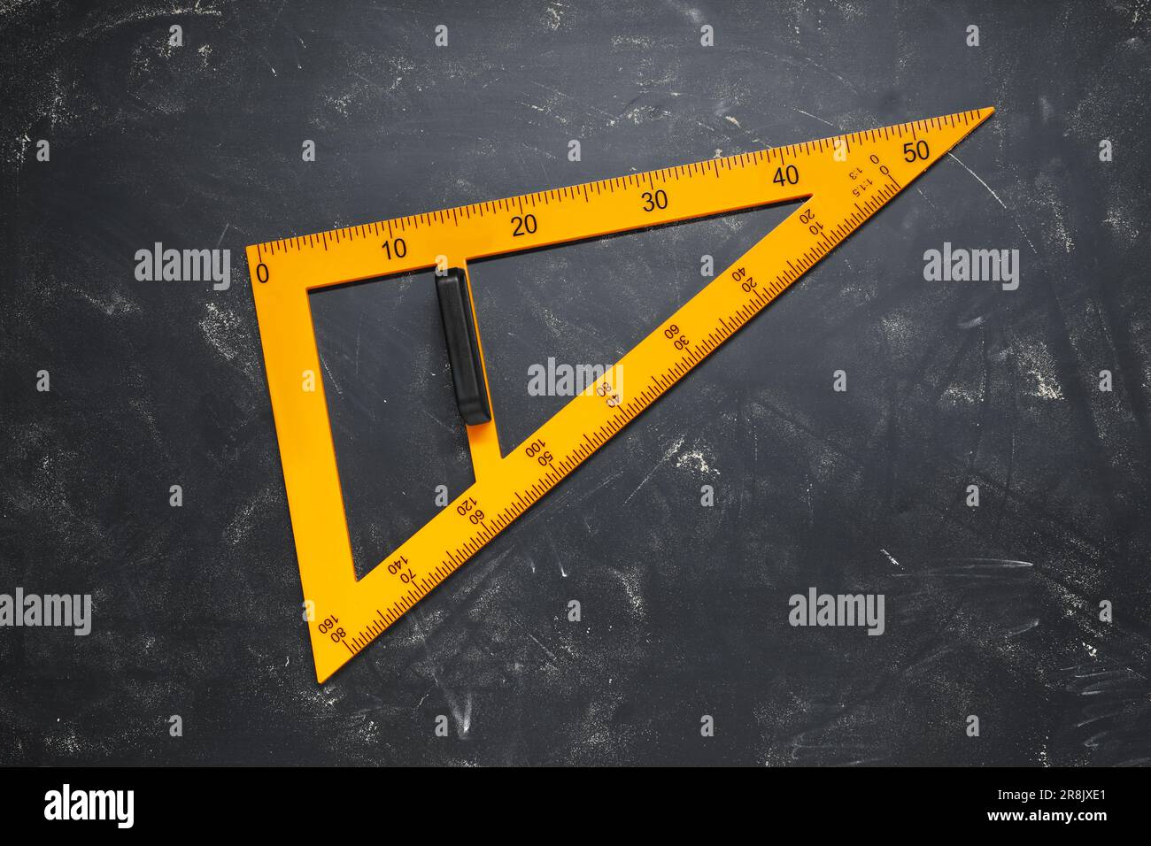Triangle ruler with measuring length markings on blackboard, top view ...