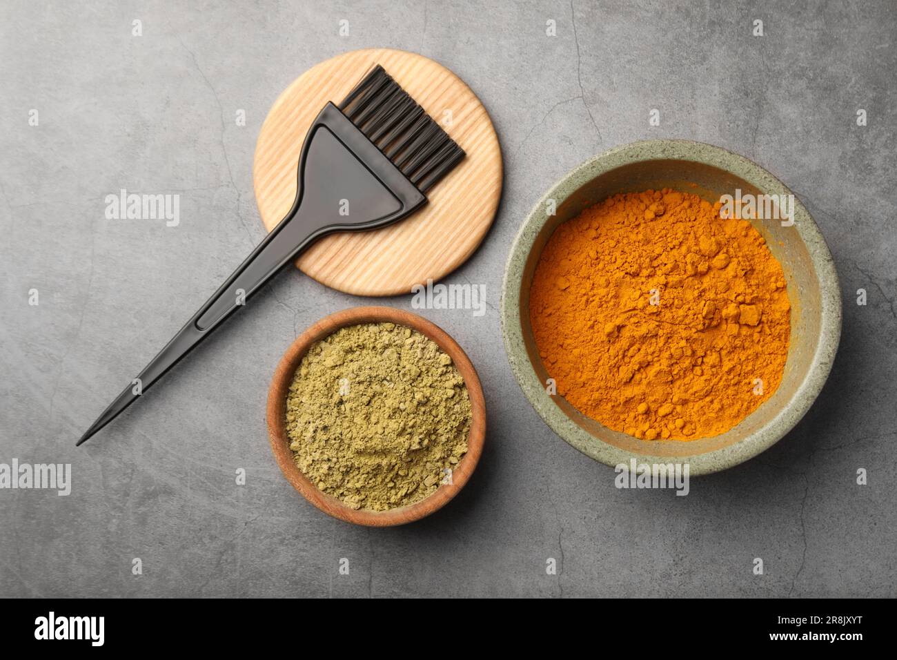 Flat lay composition with henna and turmeric powder on light grey table ...