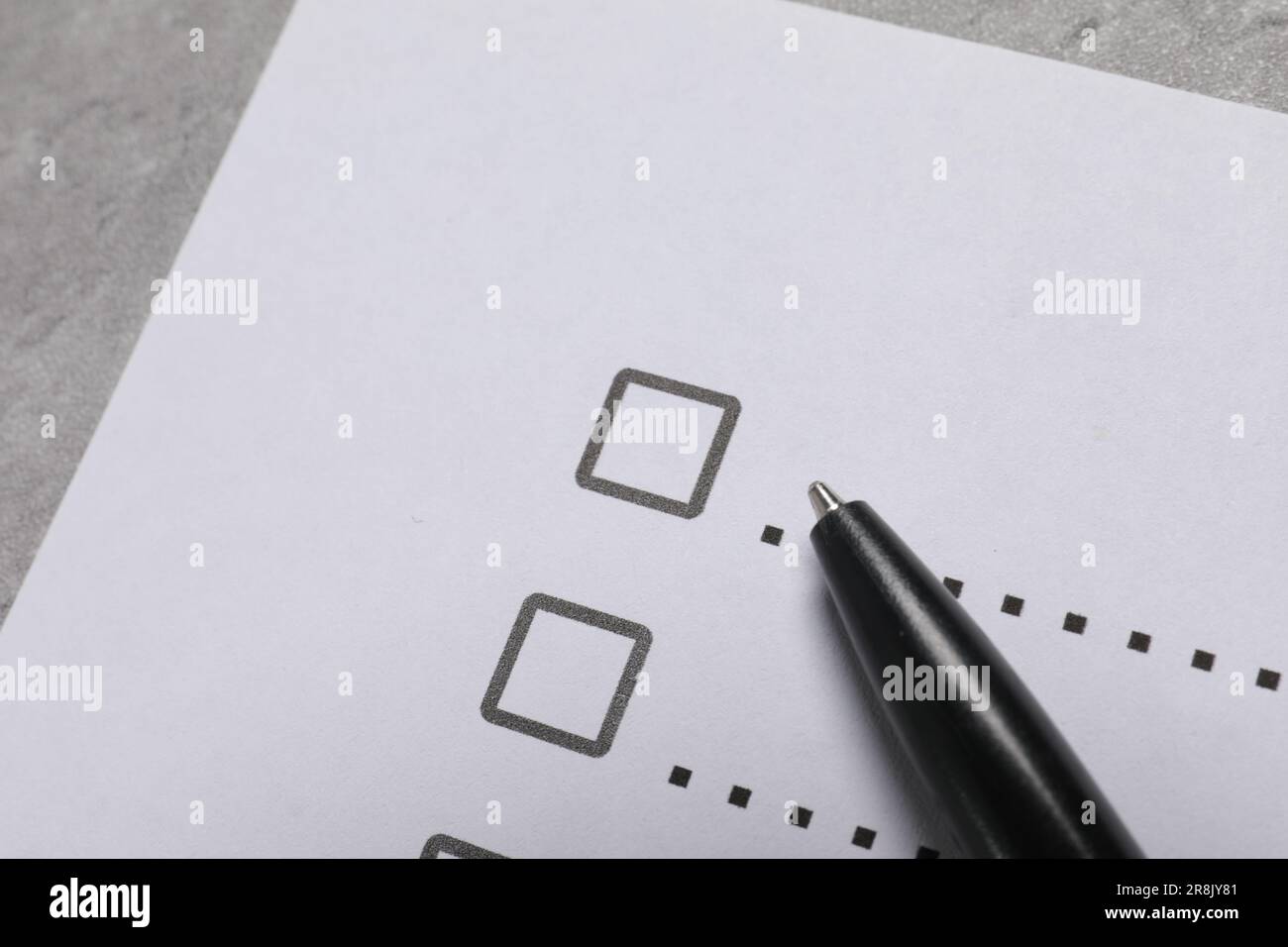 Paper sheet with checkboxes and pen on light grey table, closeup ...
