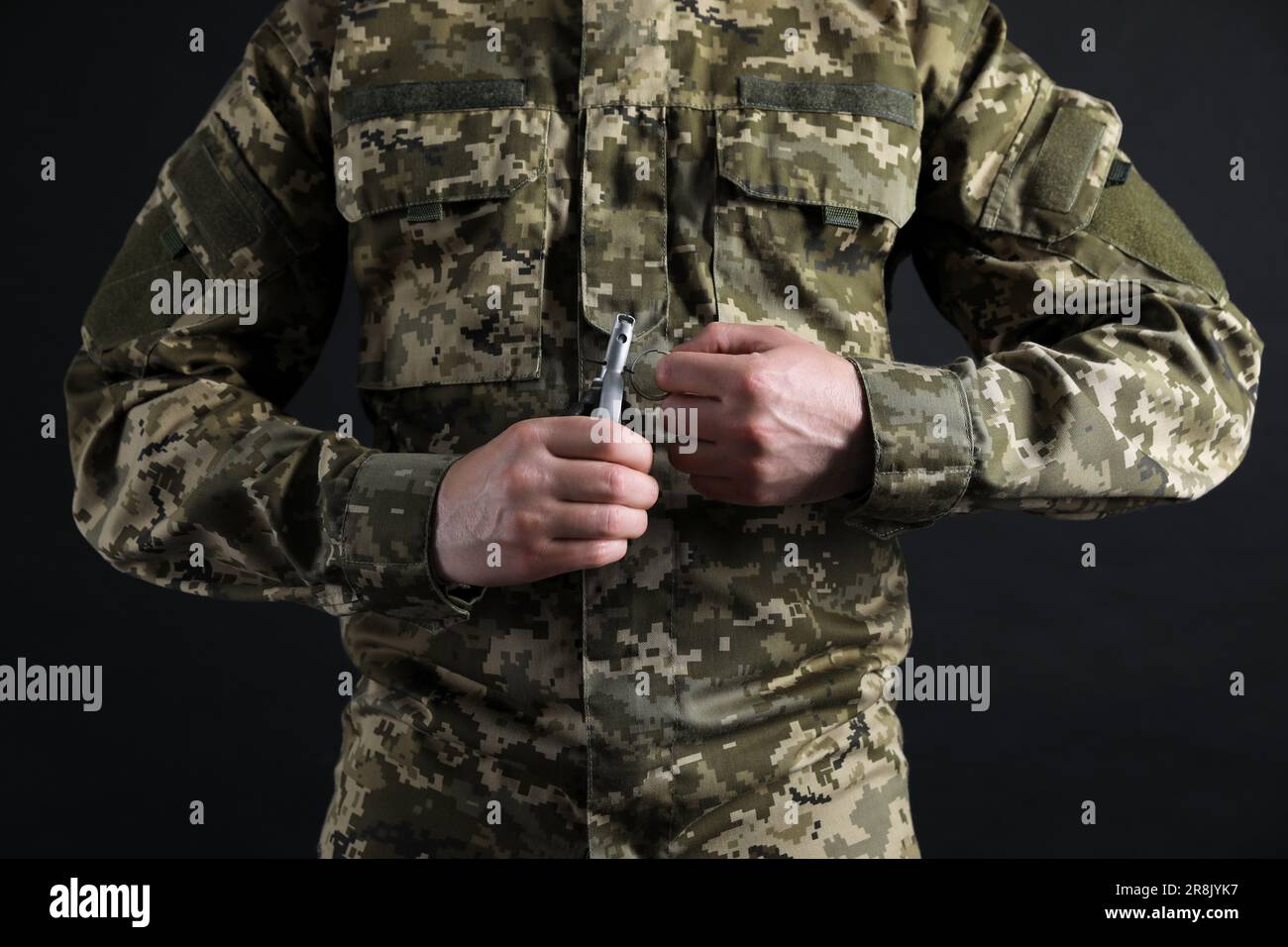 Soldier pulling safety pin out of hand grenade on black background ...