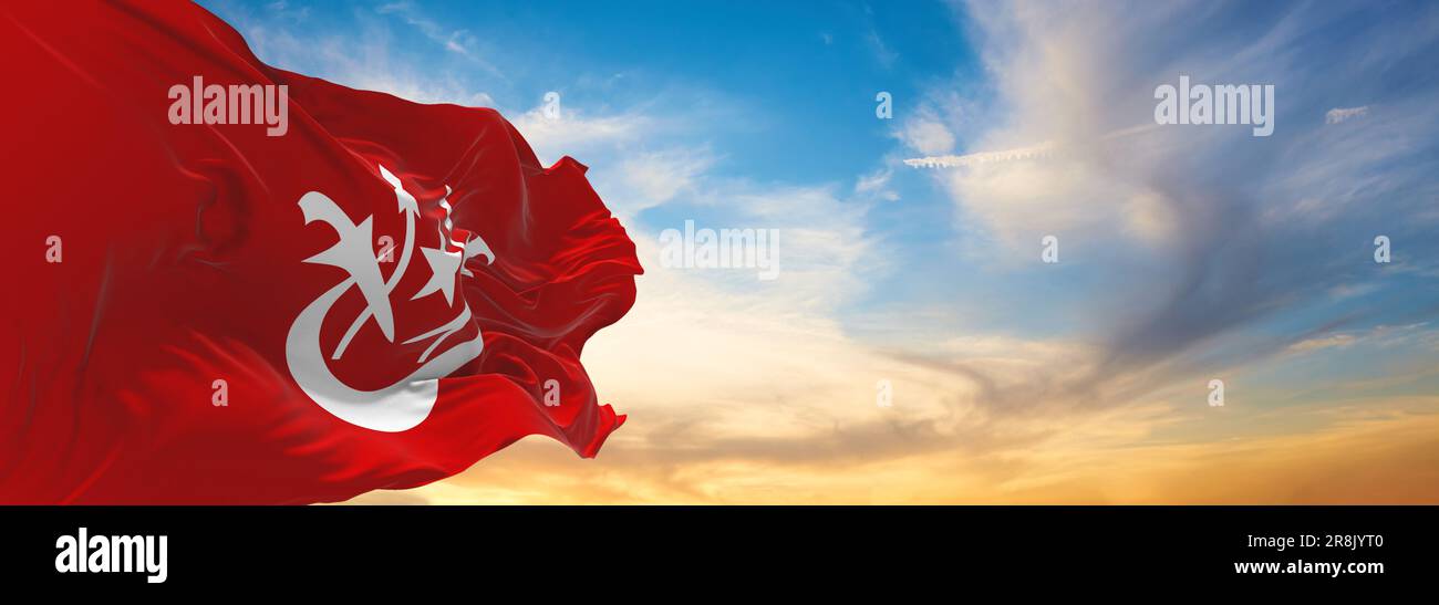 official flag of Kelantan Malaysia at cloudy sky background on sunset ...