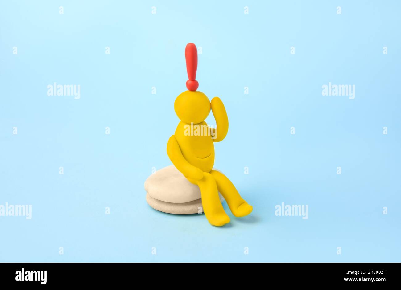 Human figure made of yellow plasticine with exclamation mark as ...