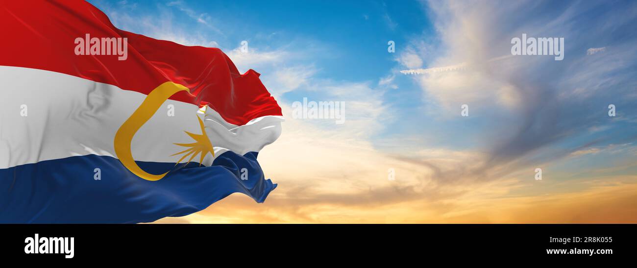 official flag of Labuan Malaysia at cloudy sky background on sunset ...