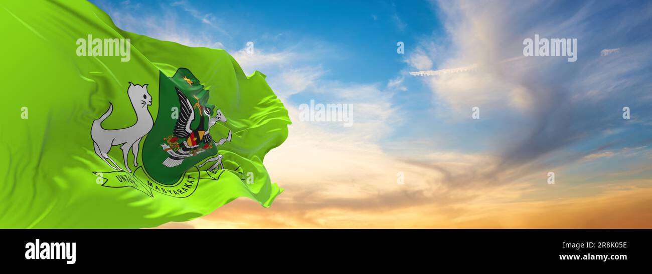 official flag of Kuching Malaysia at cloudy sky background on sunset ...