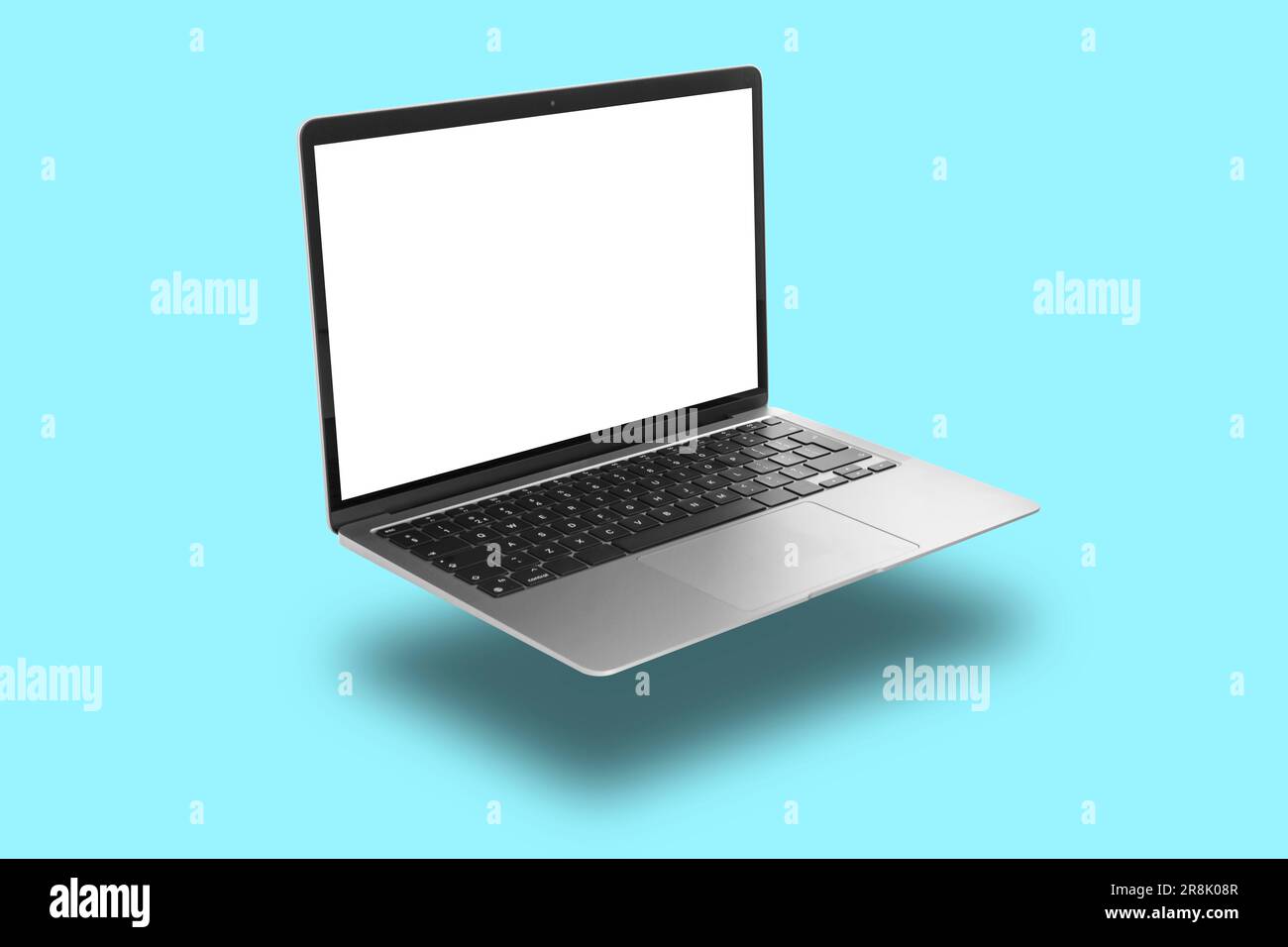 Modern laptop flying on light blue background Stock Photo - Alamy