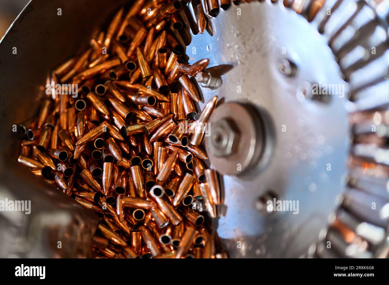 Pile of orange bullets and turning wheel at production line Stock Photo ...
