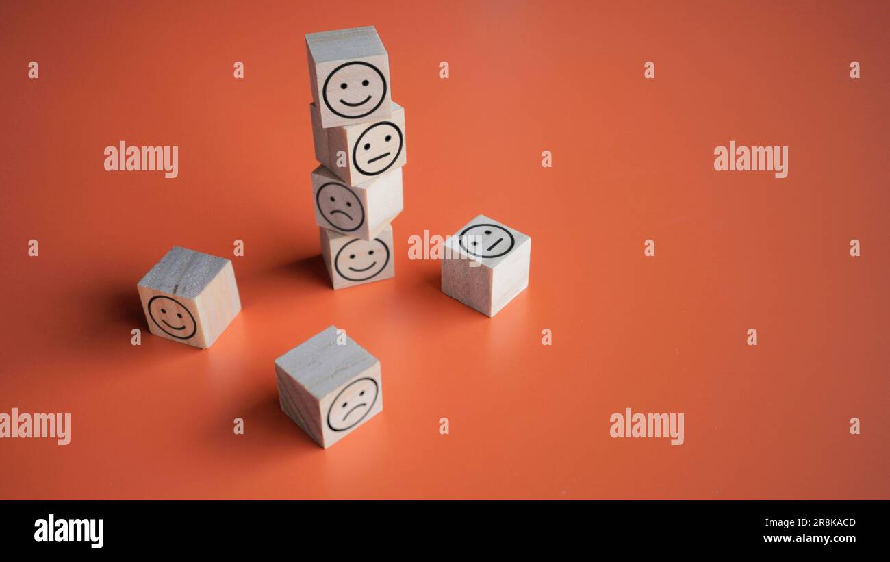 Wooden cubes with neutral, happy and sad icon. Copy space for text ...