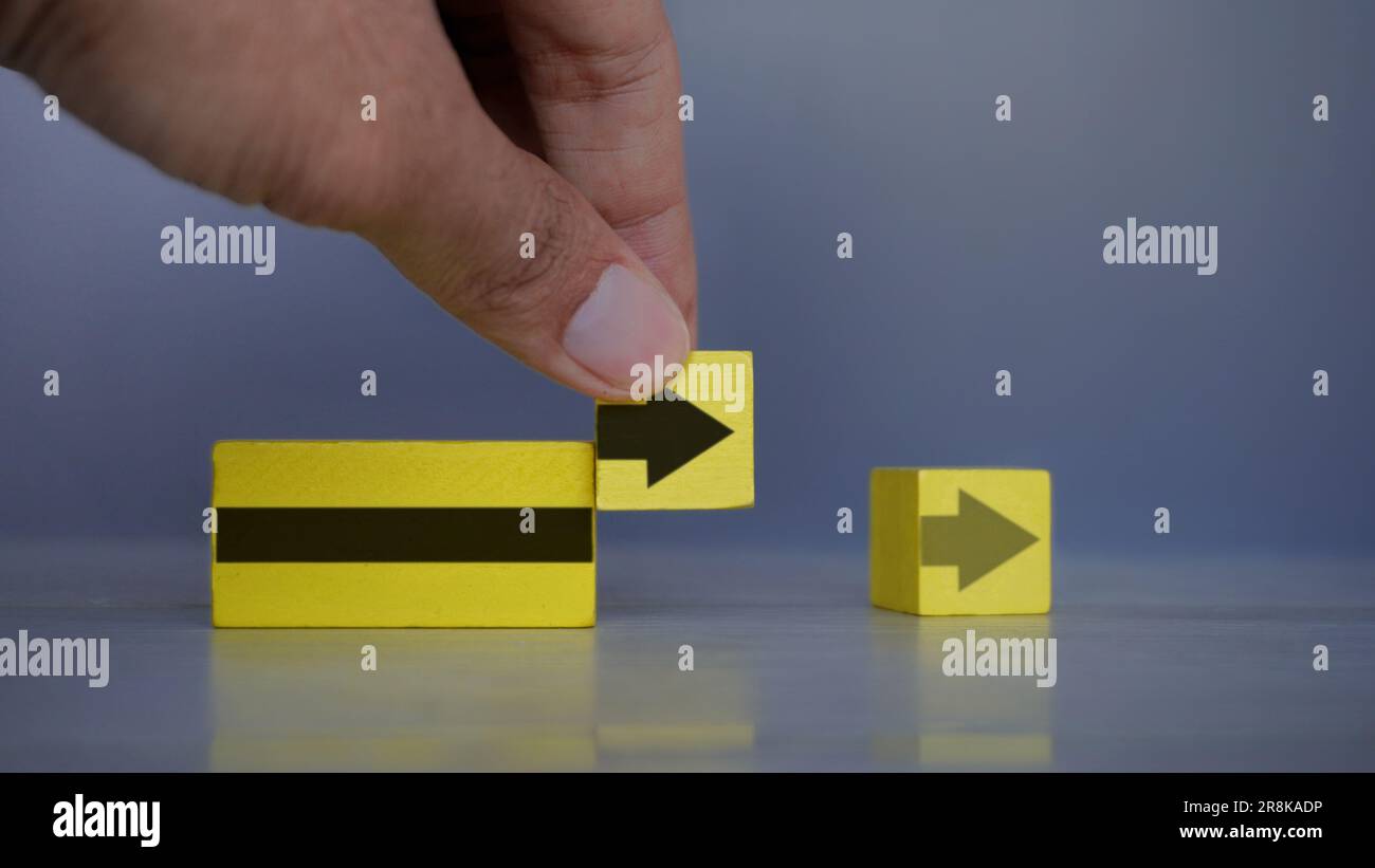 Hand holding wooden cubes with arrow icon. New strategy, changes ...