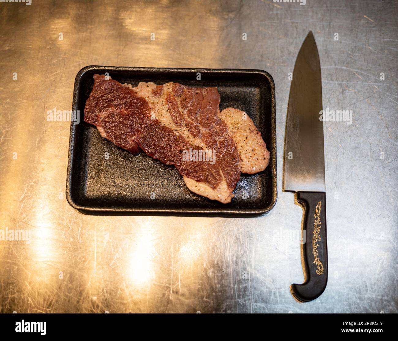 Knife and meat on kitchen table, background for advertisement and ...