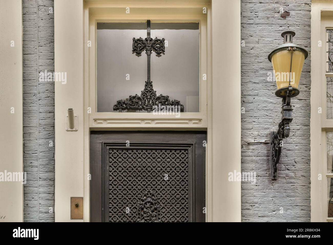 a front door with a lamp on the side and some shelves in the back wall ...