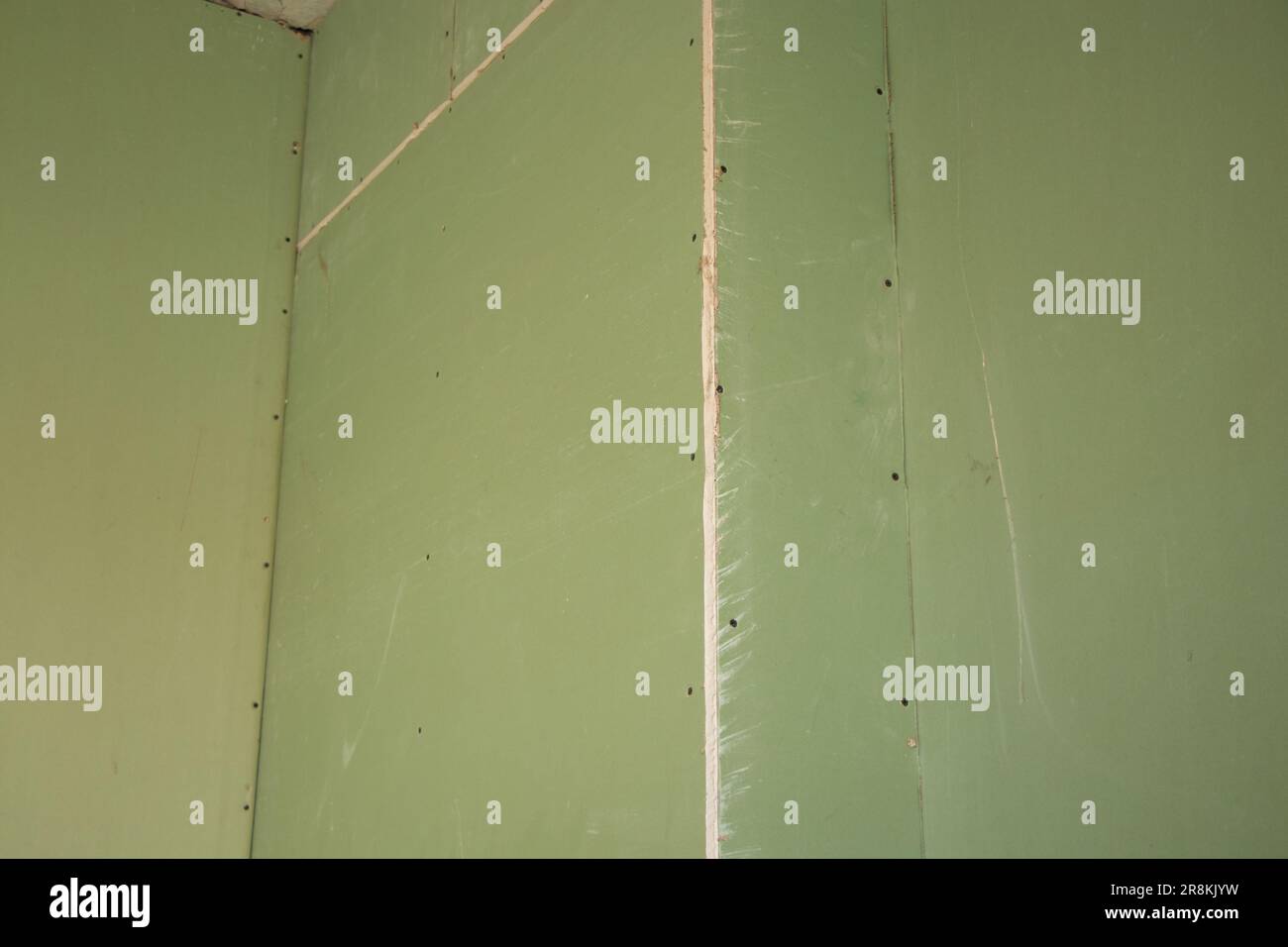 the wall is sheathed with moisture-resistant green plasterboard in the ...