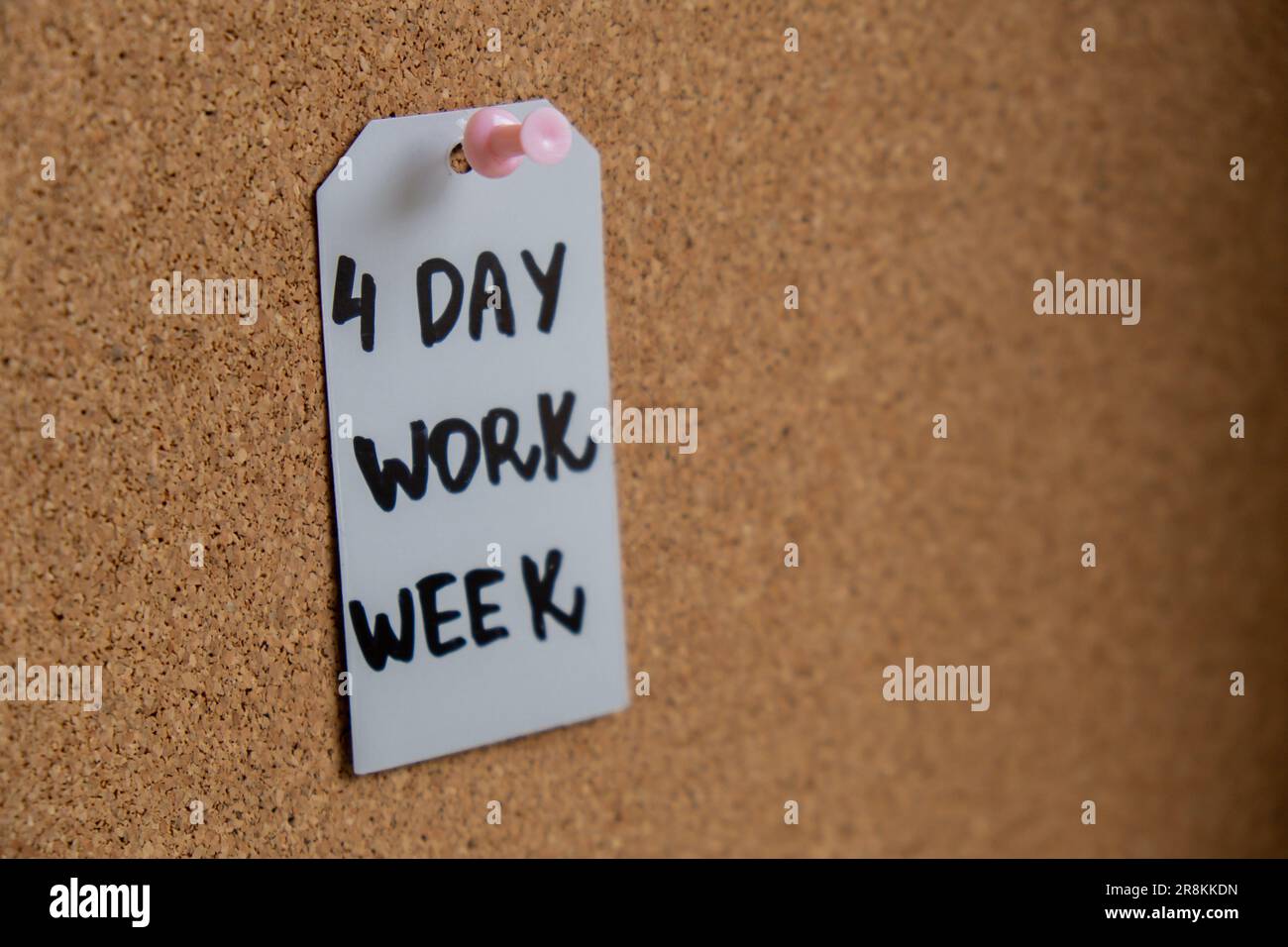 4 day work week text on paper note pinned to desk four day working week concept. Modern approach ...