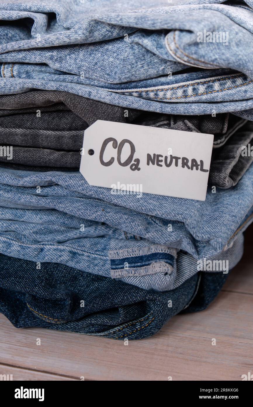 CO2 neutral emission text note on stack of jeans. Ecology nature ...