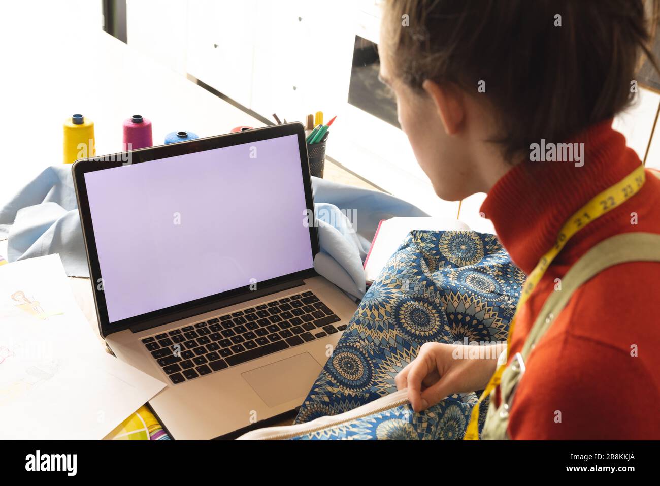 Non-binary transgender woman fashion designer looking at the laptop ...
