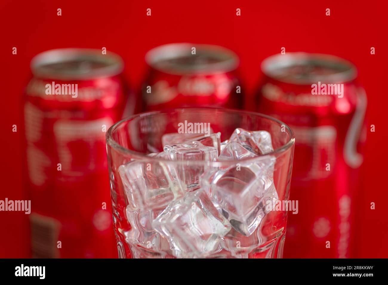 Glass full of ice cubes over red background Stock Photo - Alamy
