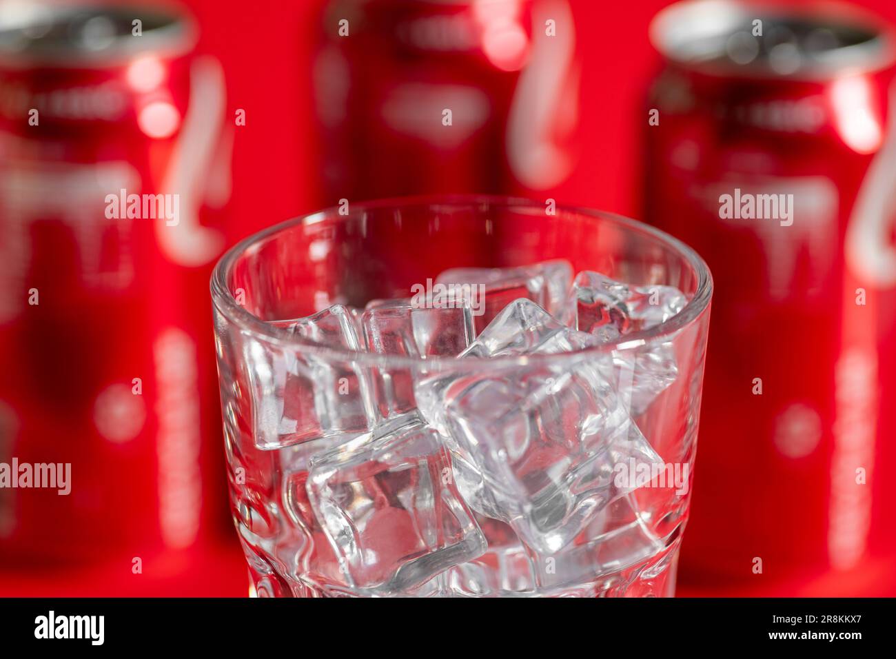 Glass full of ice cubes over red background Stock Photo - Alamy