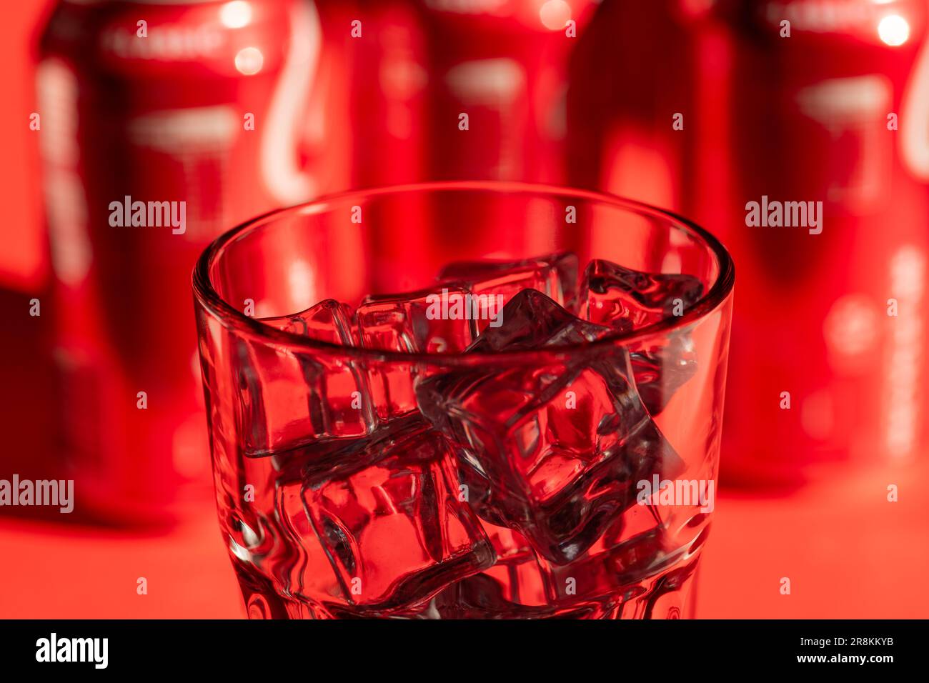 Glass full of ice cubes and a fresh cold cola over red background Stock ...