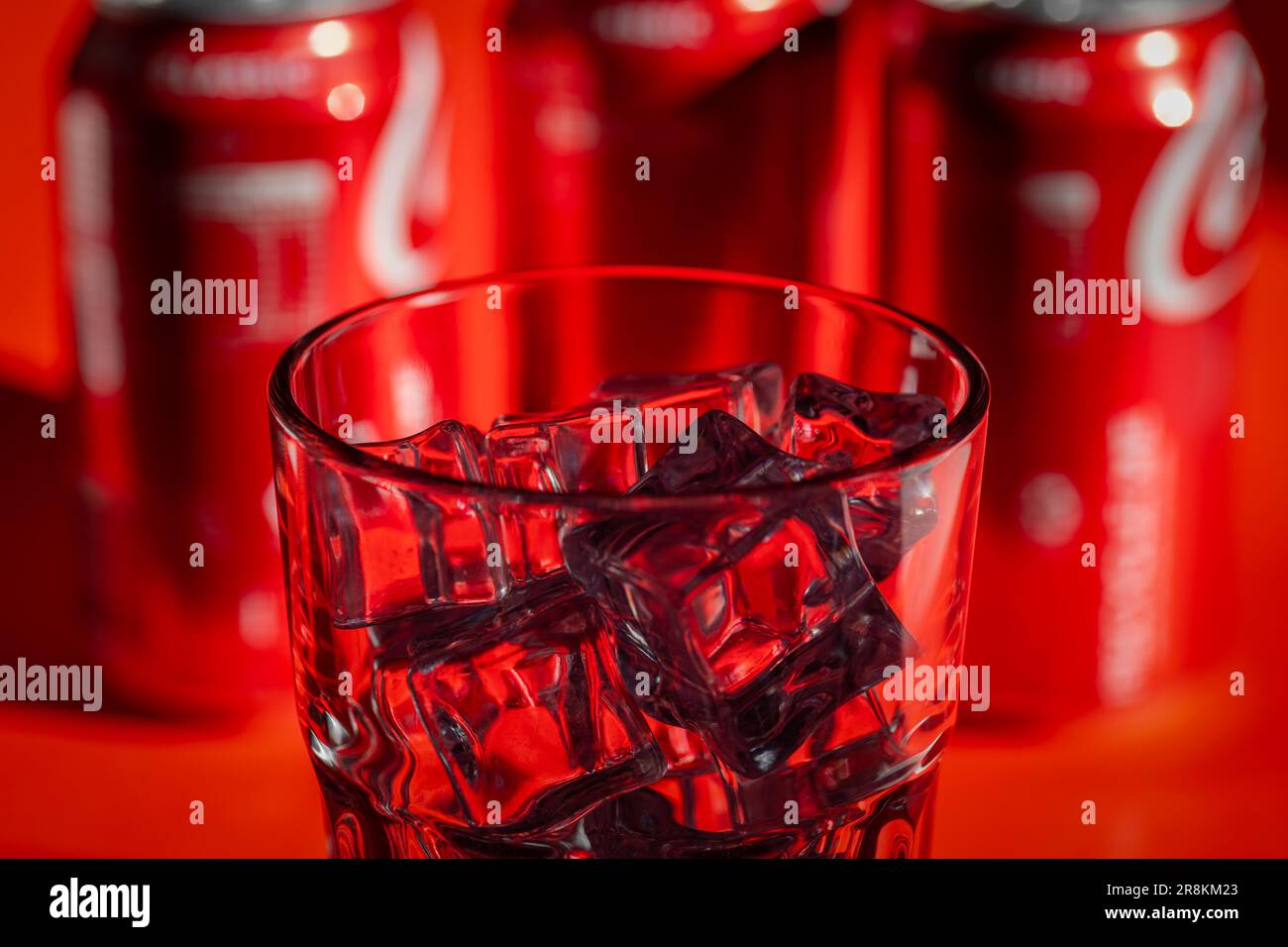 Glass full of ice cubes and a fresh cold cola over red background Stock ...