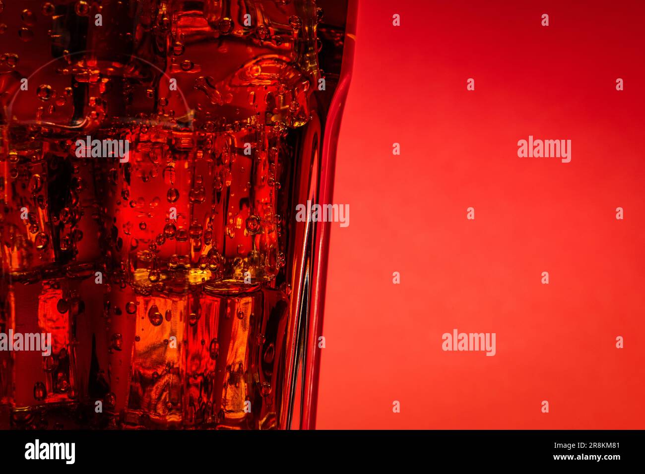 Glass full of ice cubes and a fresh cold cola over red background Stock ...