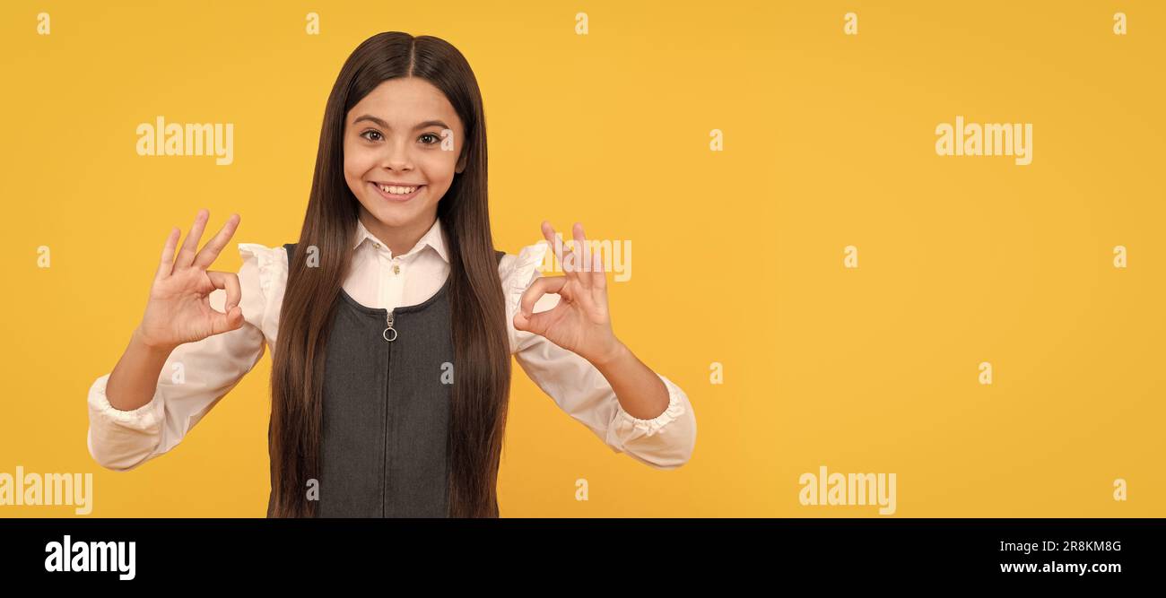 Happy girl child in school uniform smile gesturing double OK sings ...