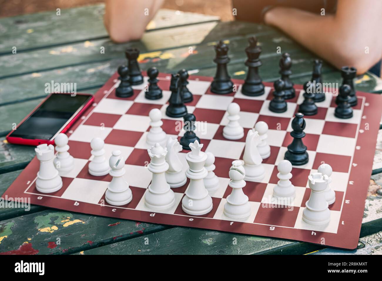 Playing chess on a flexible mobile board on a table outdoors in the ...